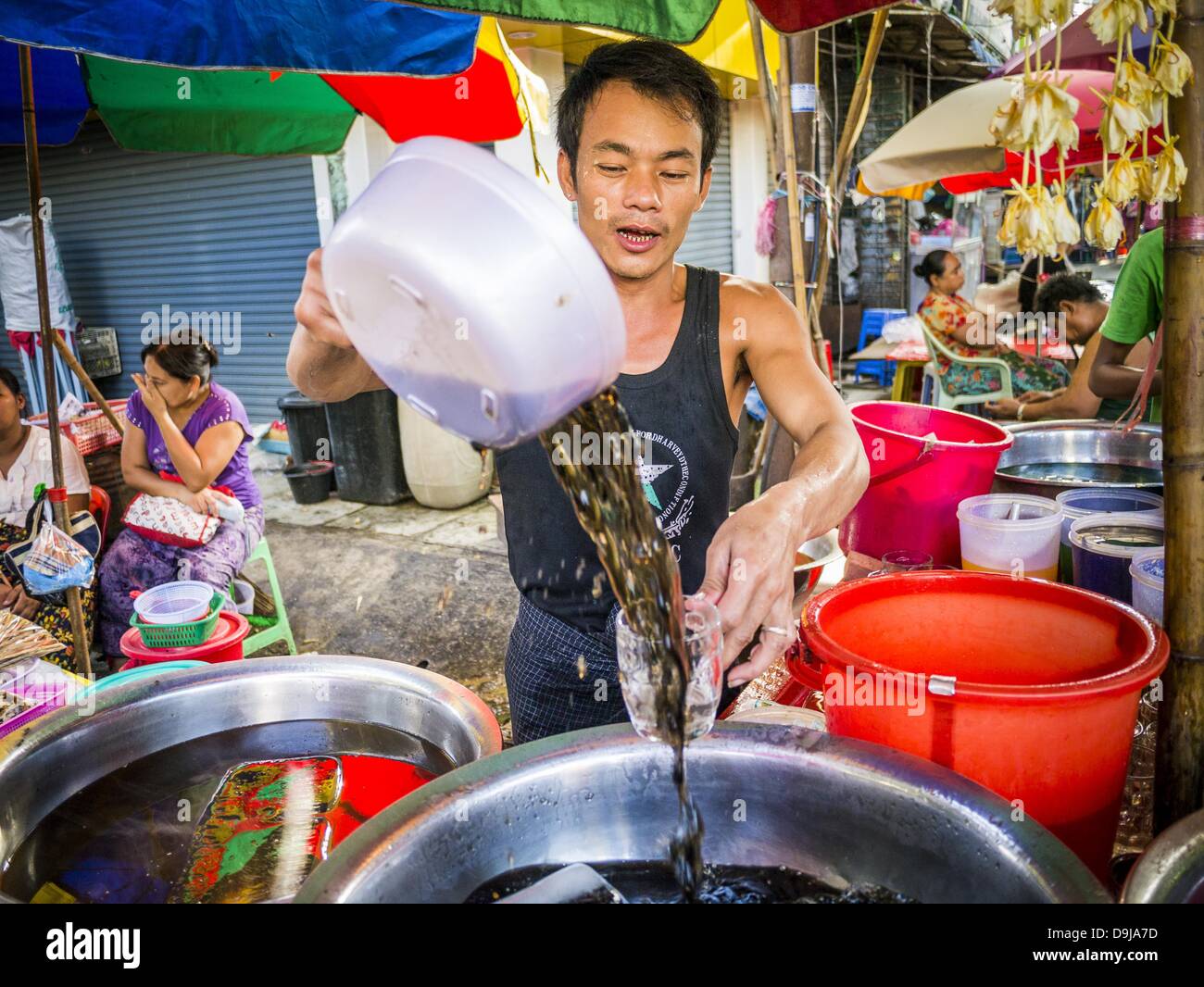 June 16, 2013 - Yangon, Union of Myanmar - A juice vendor works in a ...