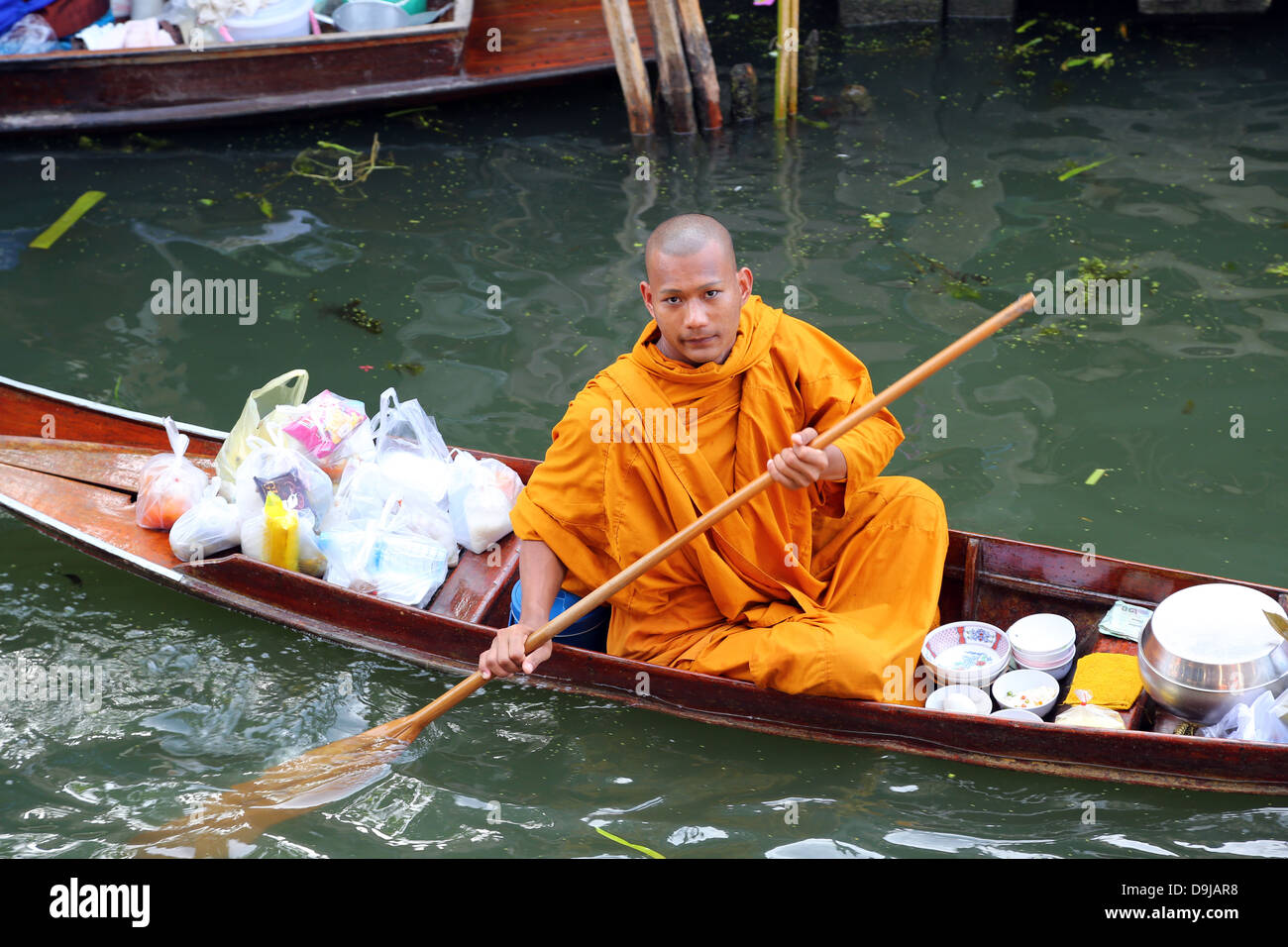 Buddhist Monk in a boat at Damnoen Saduak Floating Market, Ratchaburi ...