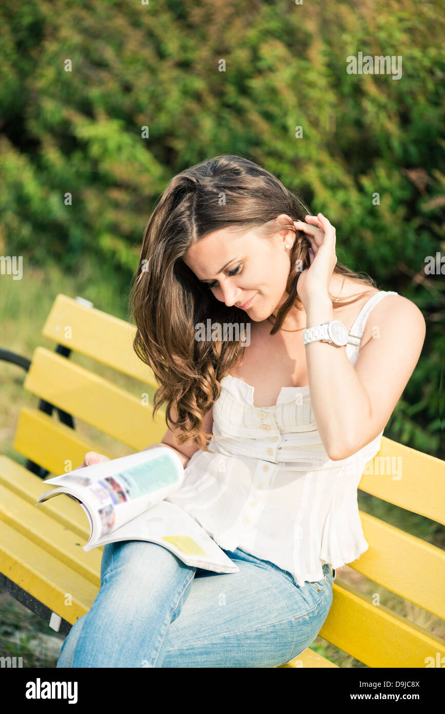 Woman read a magazine in park Stock Photo - Alamy