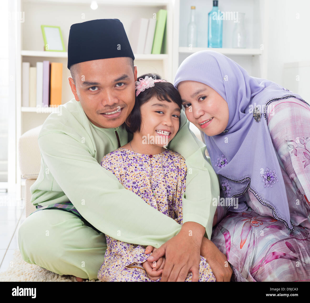 Muslim parents hugging child. Southeast Asian Malay family lifestyle ...