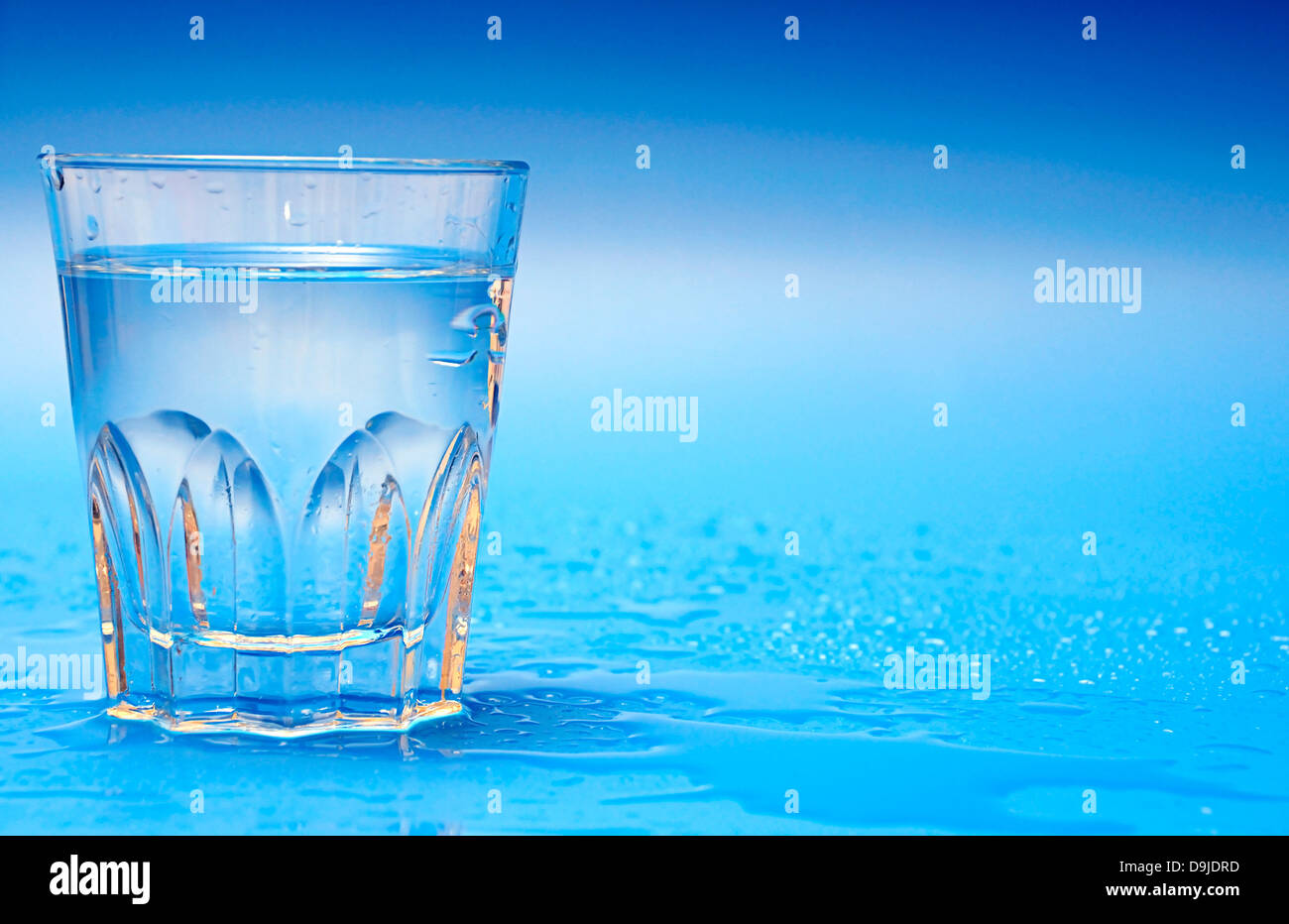 glass of clean water on a blue surface with water drops Stock Photo - Alamy