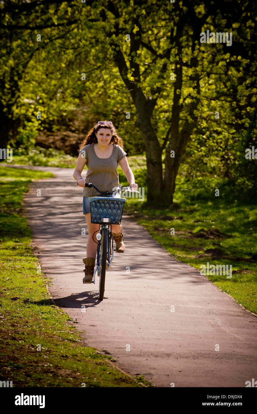 Young caucasian woman, casually dressed in a short denim skirt riding a ...