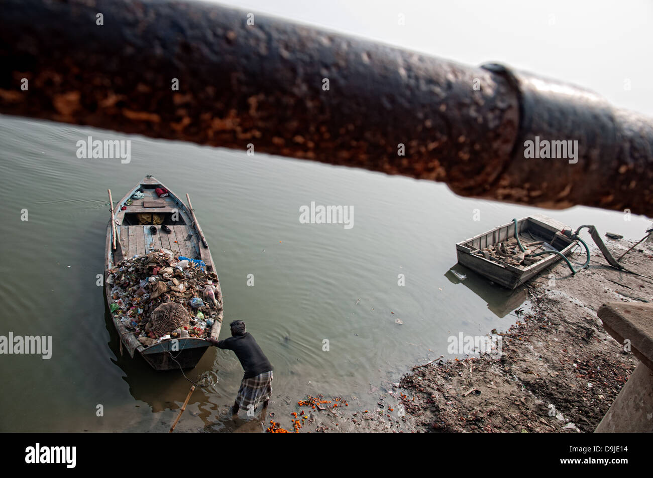 Man carrying garbage away in his boat, Varanasi, Benares, Uttar Pradesh ...