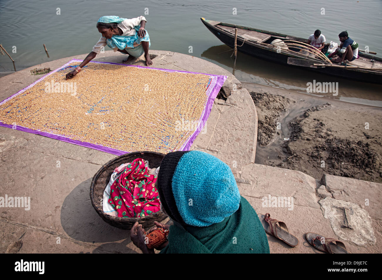 Elderly couple drying seeds in the sun on the ghats, Varanasi, Benares ...