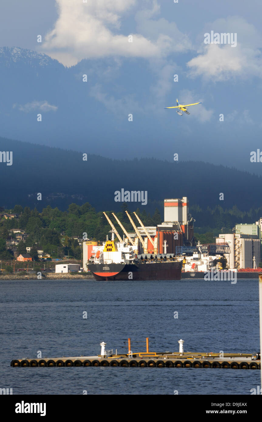 Seaplane coming in for a landing over a cargo ship into Vancouver ...