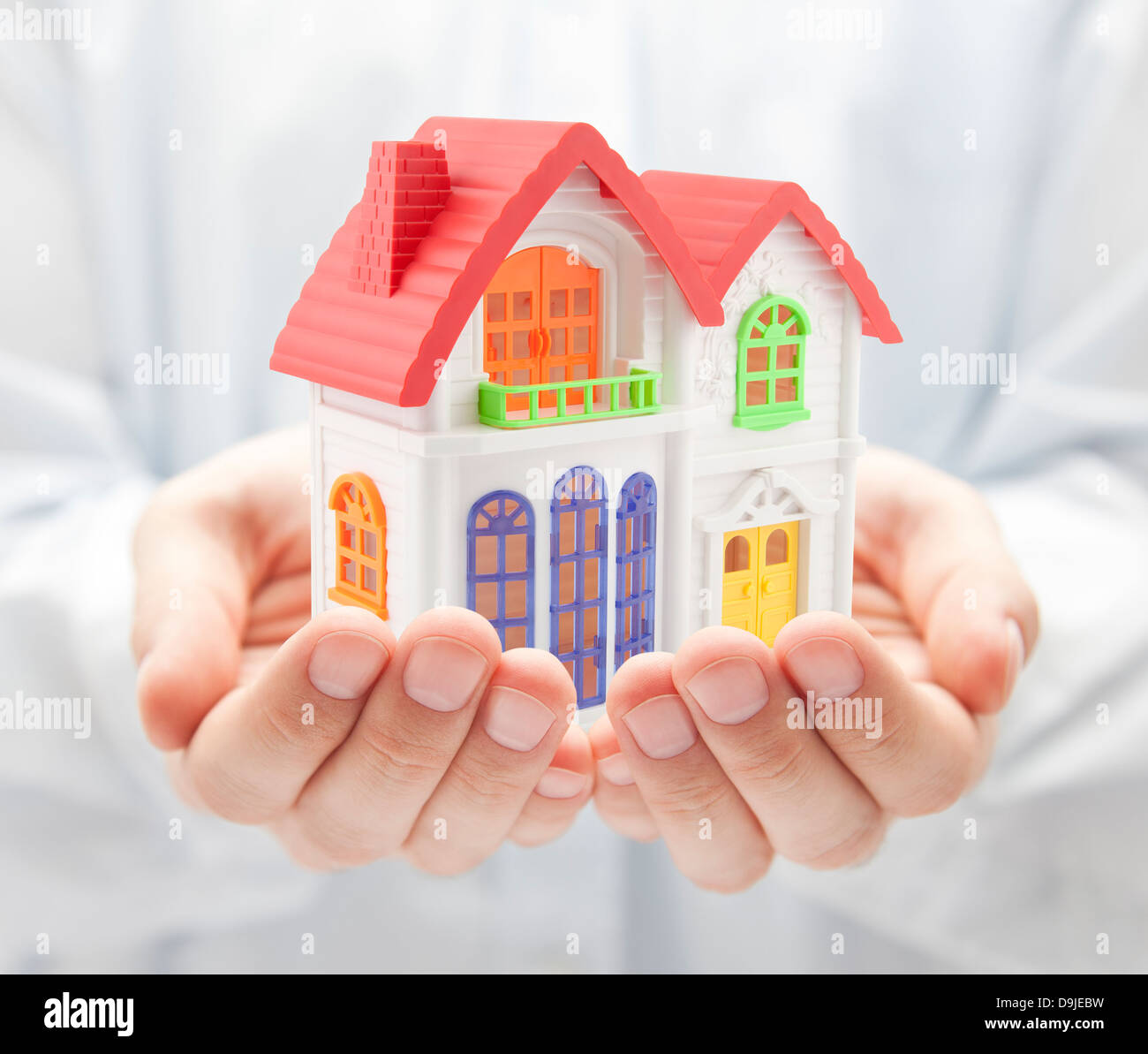 Colorful house in hands Stock Photo - Alamy