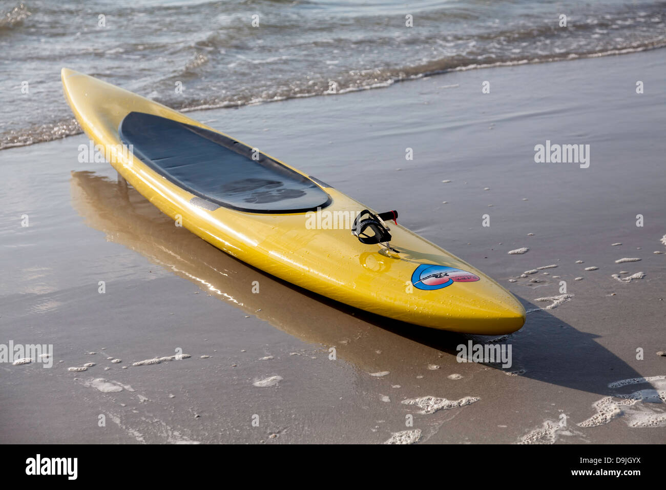 Yellow ocean sea kayak sitting on beach at the surf line Stock Photo ...