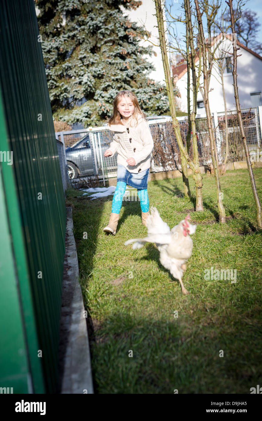 young girl playing with a hen on the backyard Stock Photo - Alamy
