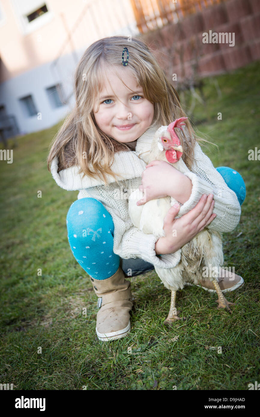 young girl playing with a hen on the backyard Stock Photo - Alamy