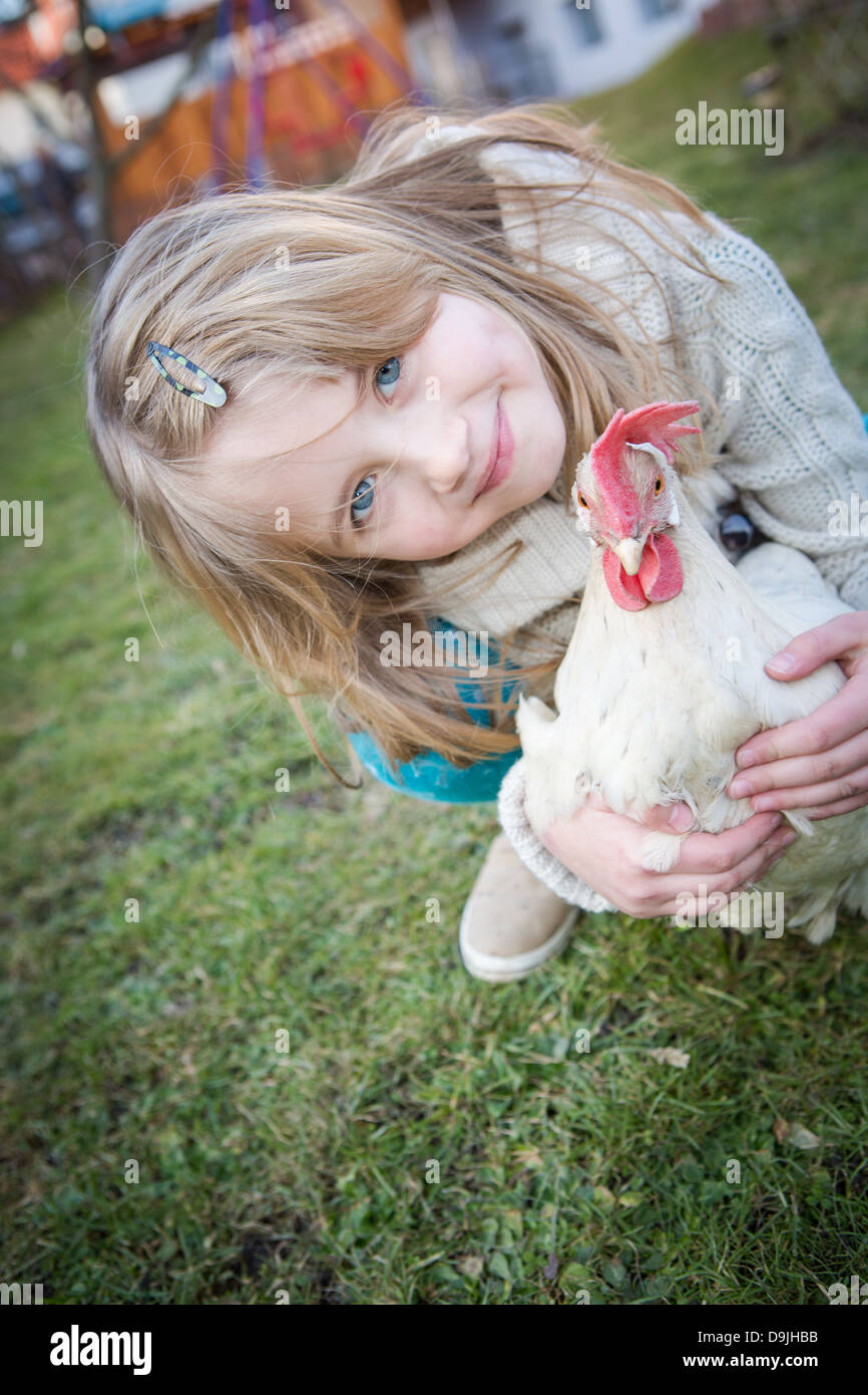 young girl playing with a hen on the backyard Stock Photo - Alamy