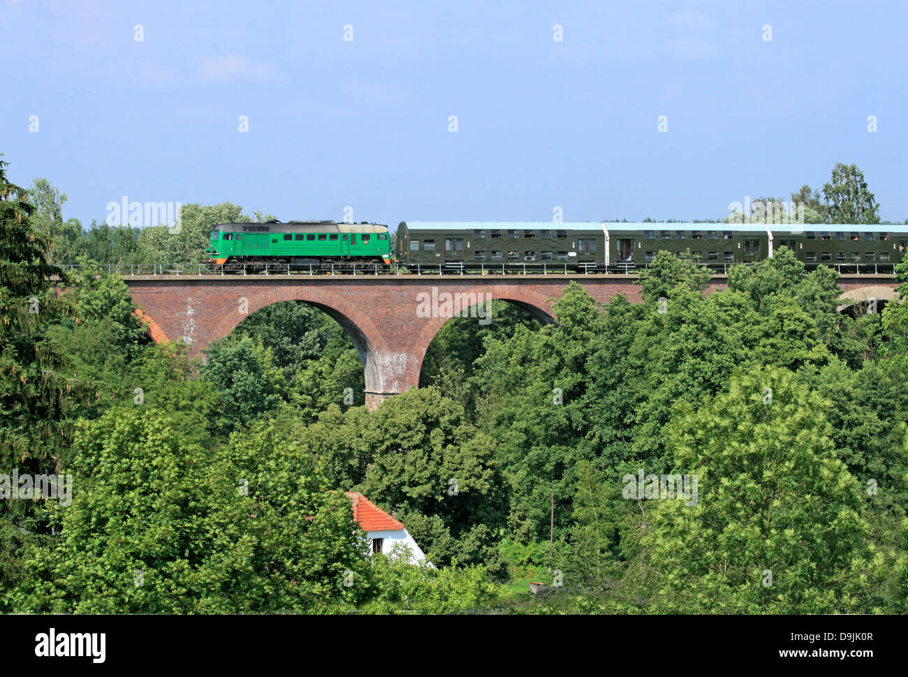 Passenger train passing through the big stone bridge Stock Photo - Alamy