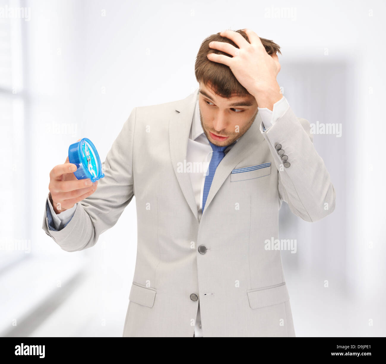 handsome businessman looking at alarm clock Stock Photo - Alamy