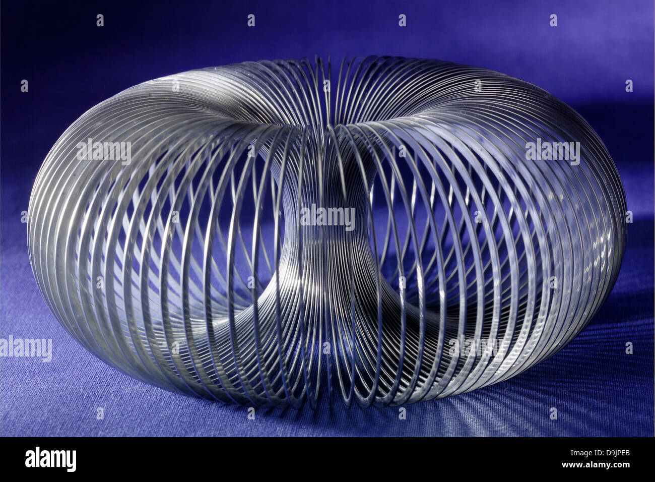 Stretched spring in Circle on Blue Background Stock Photo - Alamy