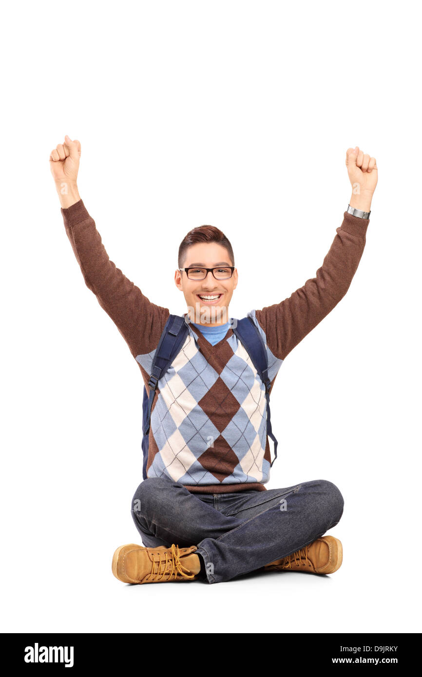 Handsome young man sitting on a floor with raised hands gesturing ...