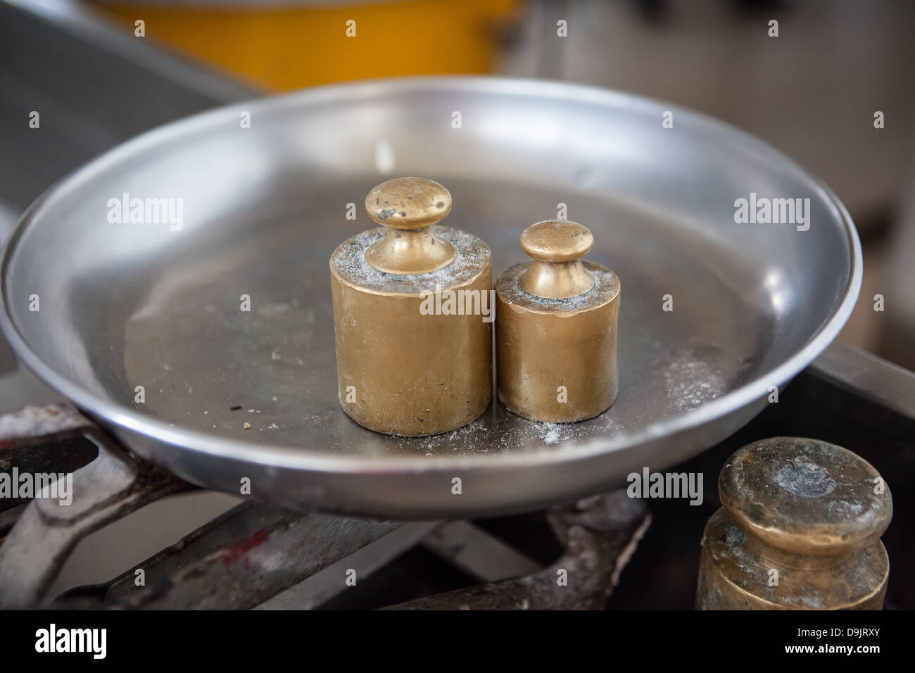 A set of antique weights on a scale used for measuring ingredients at ...