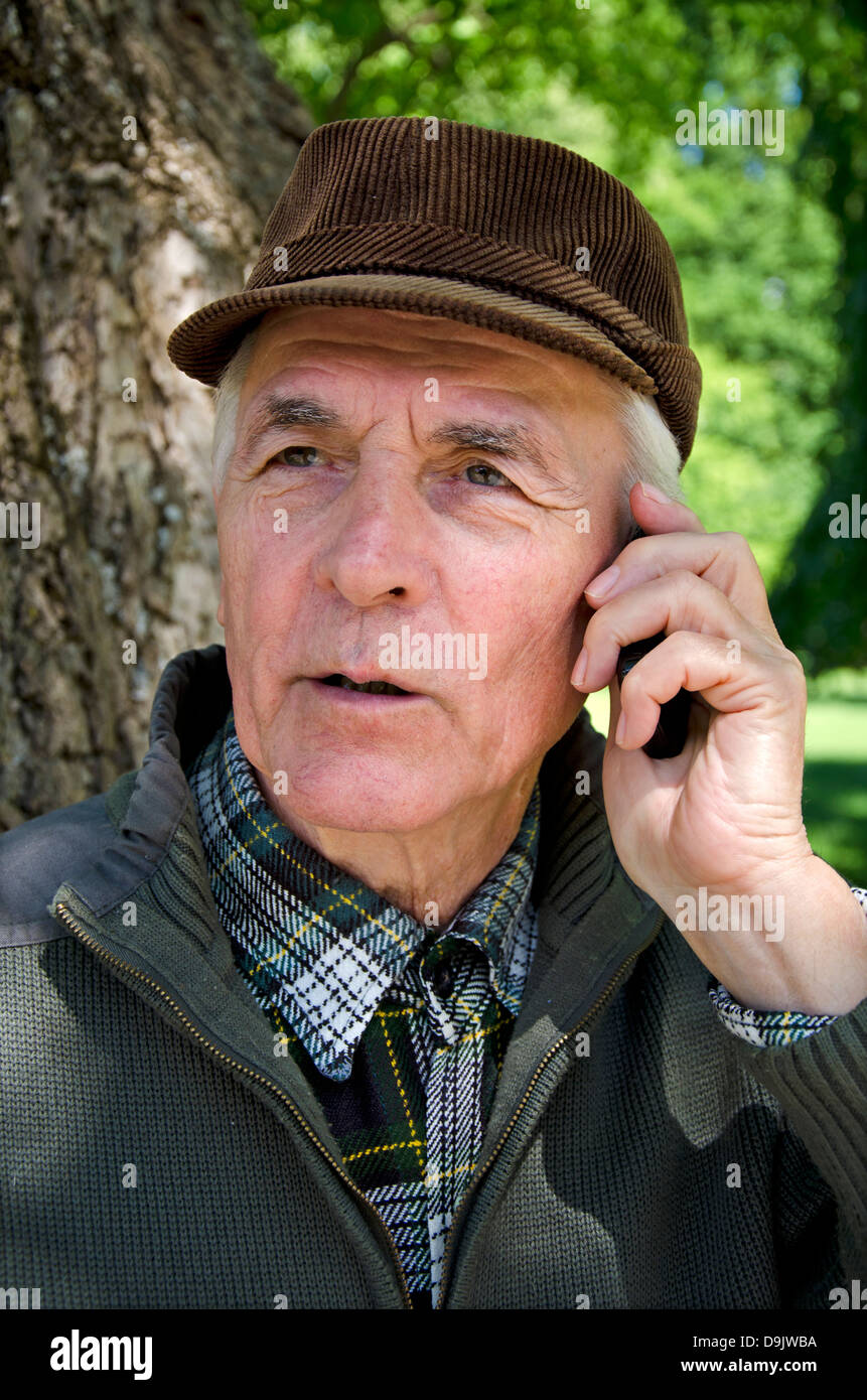 Senior phones under tree Stock Photo - Alamy