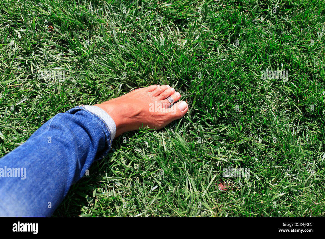 Bare feet in green grass, woman relaxing in nature Stock Photo - Alamy
