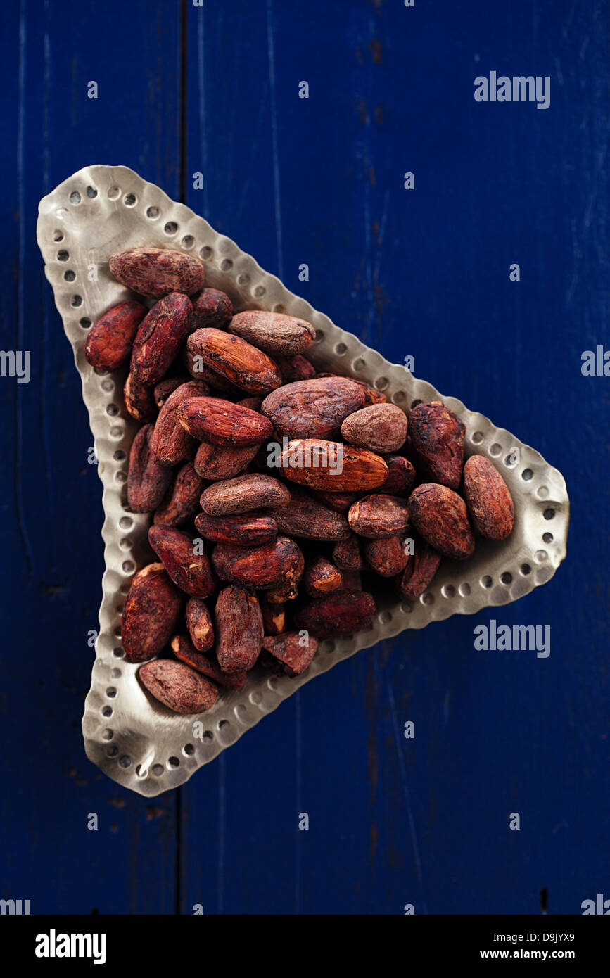 roasted cocoa chocolate beans on dark blue wood background Stock Photo ...