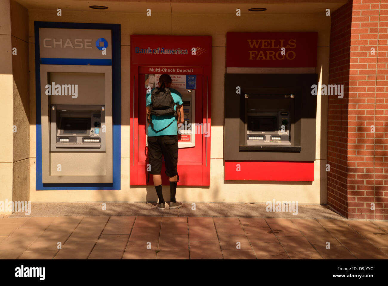 A young man uses an ATM on a college campus Stock Photo - Alamy