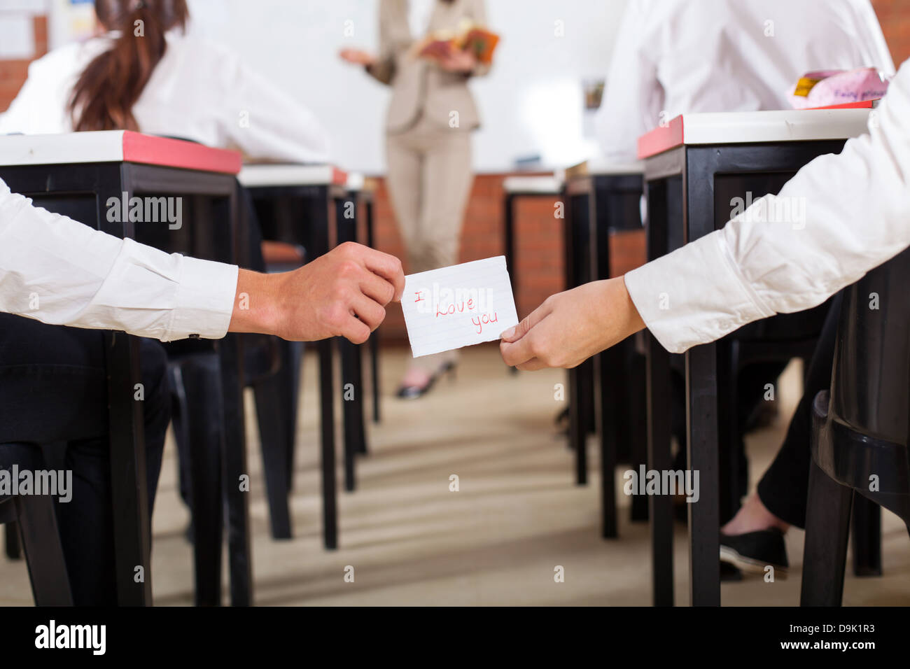 school boy passing a I Love You note to a girl in classroom Stock Photo ...