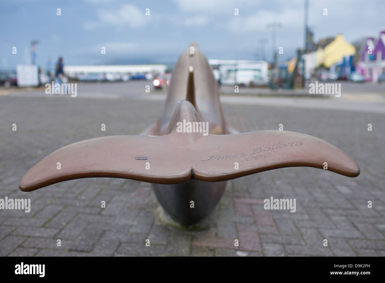A visitor sits on the bronze statue of Fungie the Dolphin on the Harbor ...