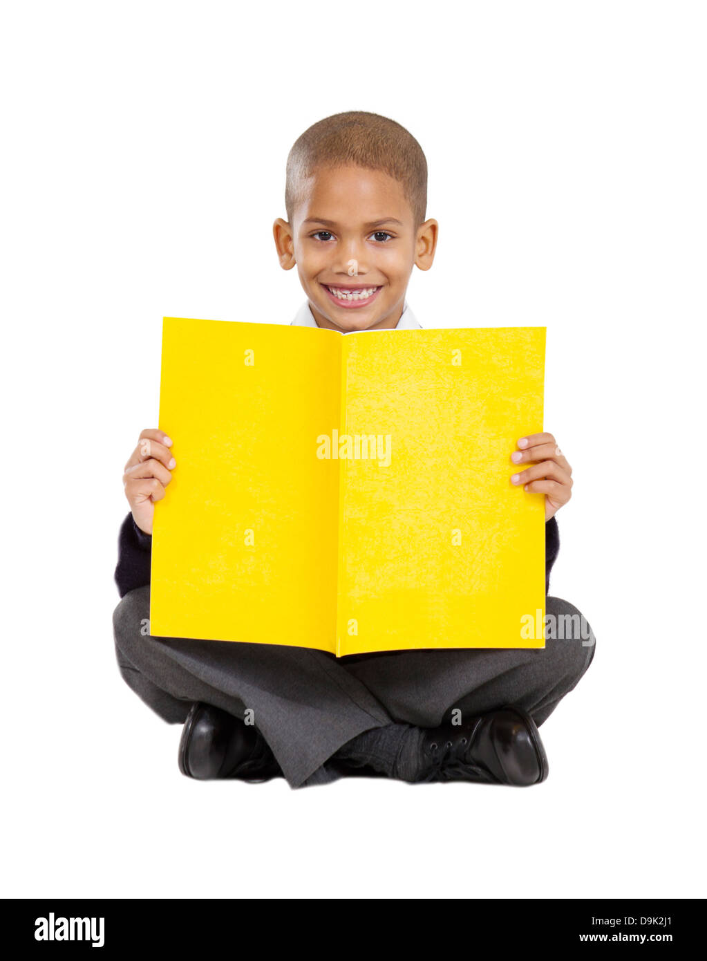 primary schoolboy sitting on floor and reading Stock Photo - Alamy