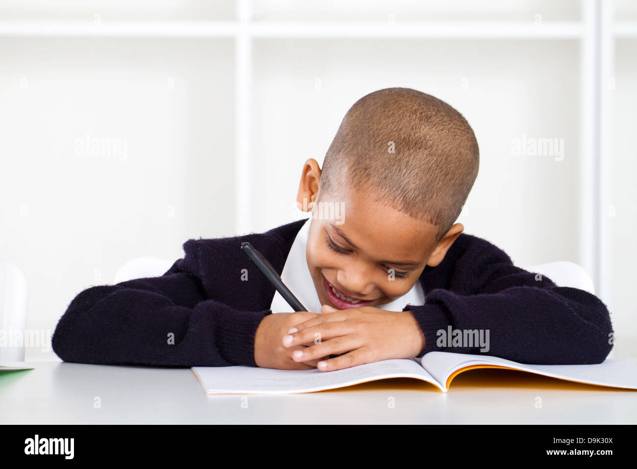 cute primary schoolboy writing homework Stock Photo - Alamy