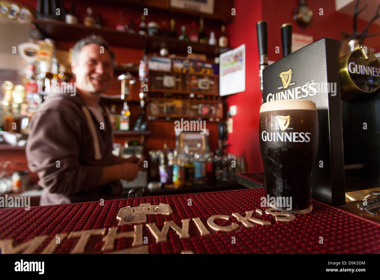 A barman serves a Guinness in one of Kenmares many pubs in thecenter of ...