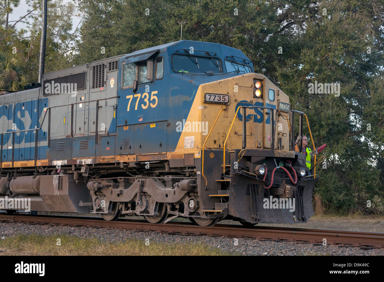CSX engine 735 with a flagman is pulling a freight train through a ...