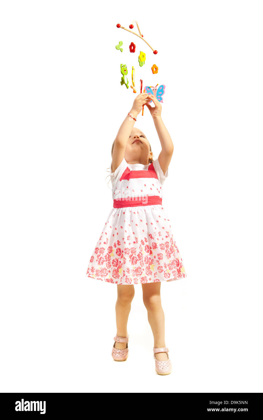 Toddler girl catching wooden toys from carousel isolated on white ...