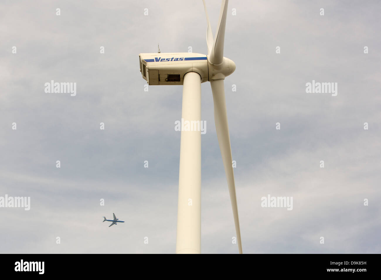 A plane flying past a wind turbine in Amsterdam, Netherlands Stock ...