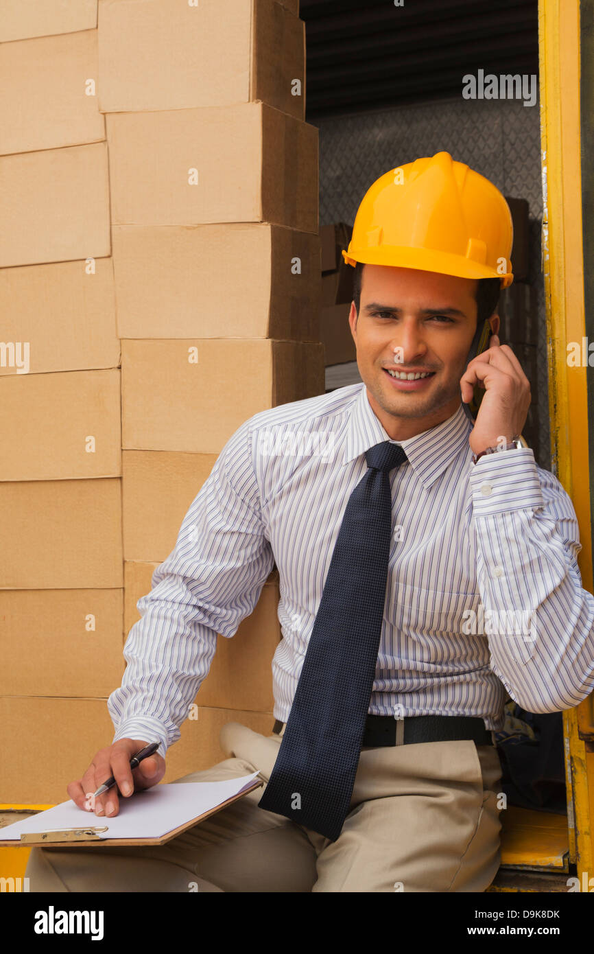 Man doing inventory and talking on a mobile phone Stock Photo - Alamy