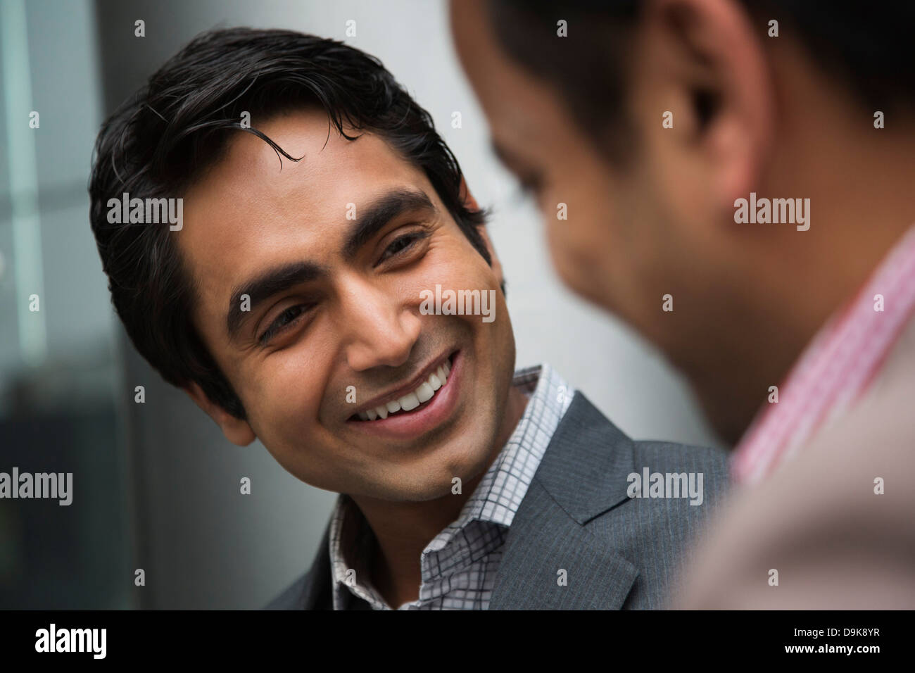 Two businessmen smiling at each other Stock Photo - Alamy