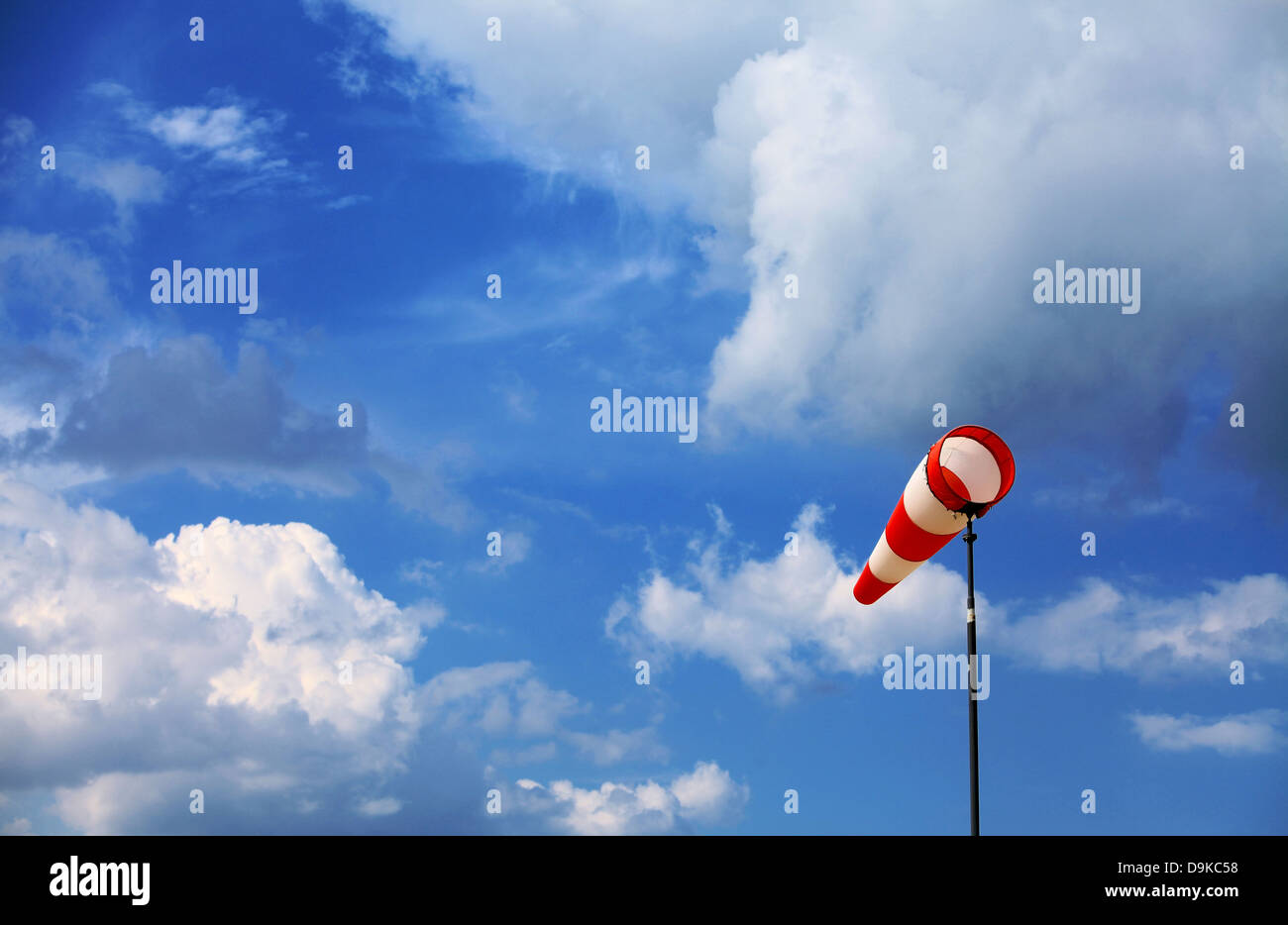A red wind vane against a blue cloudy sky Stock Photo - Alamy