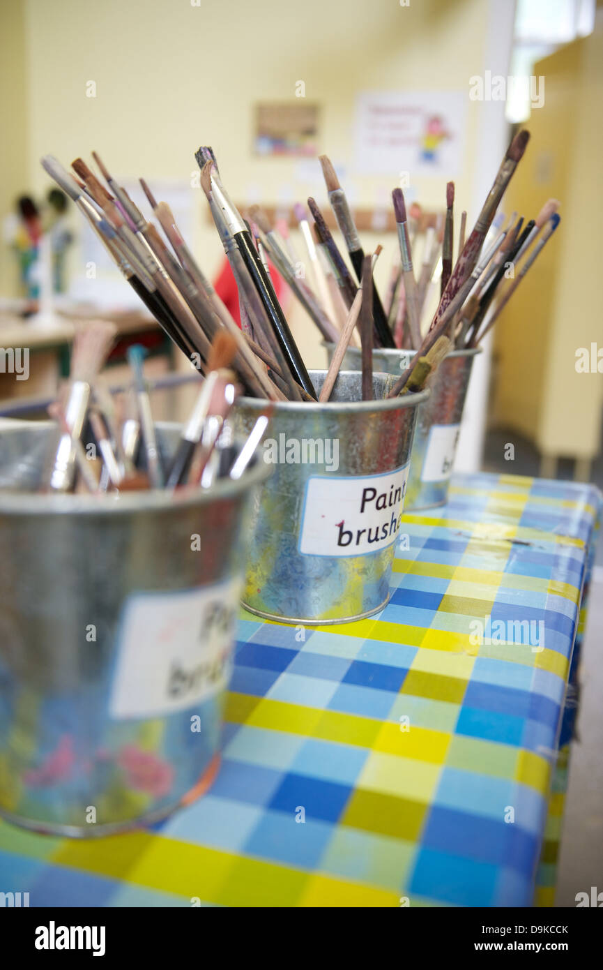 Pots of paint brushes in a classroom ready for use Stock Photo - Alamy