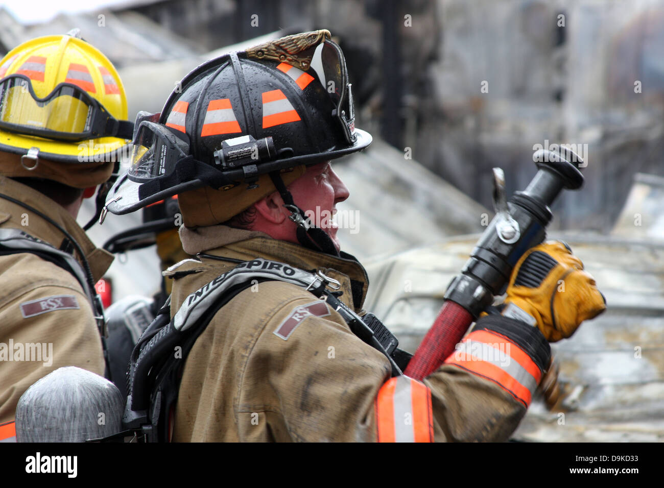 Firefighters on the scene of a fire Stock Photo - Alamy