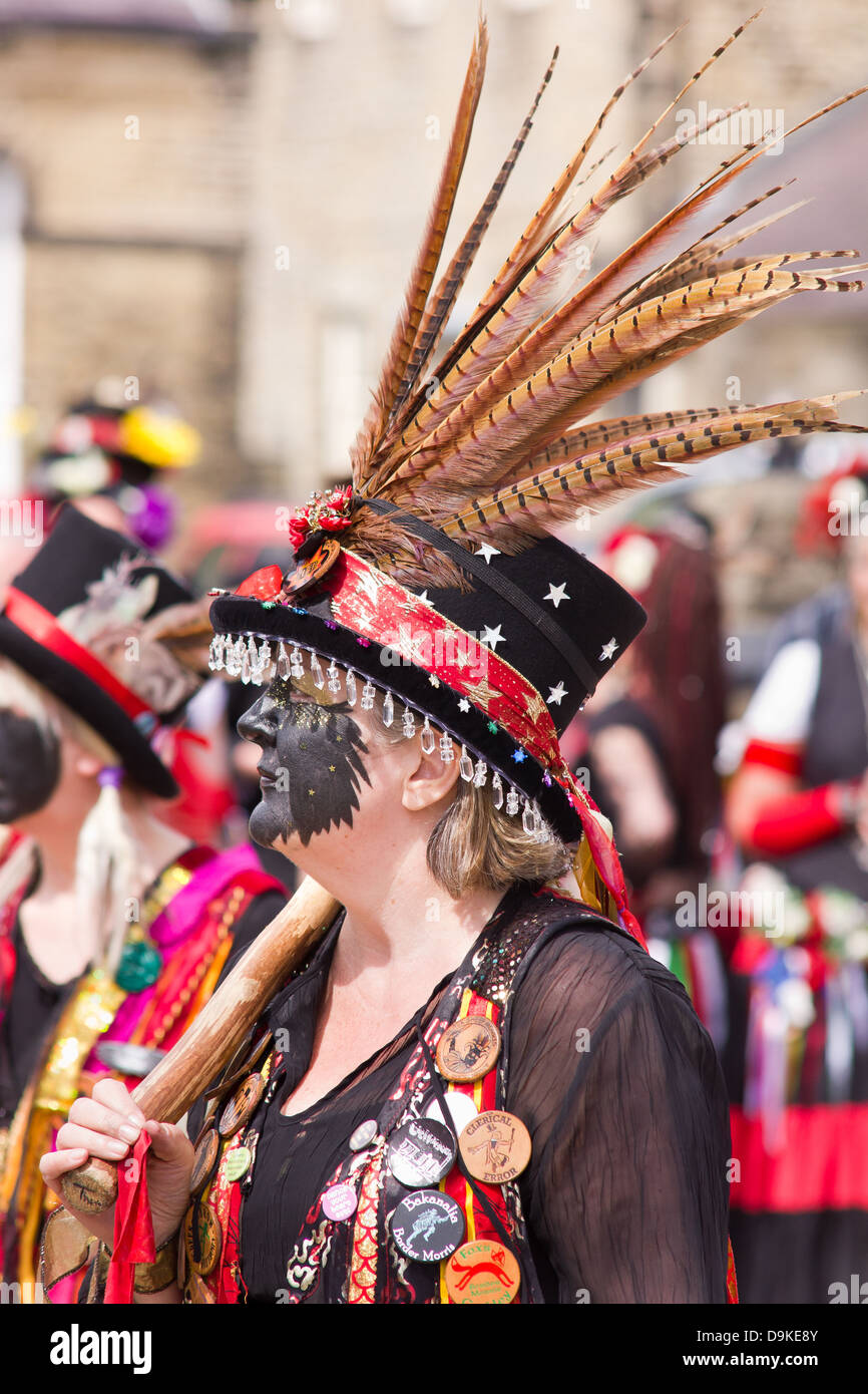 female Morris dancer with black face and feathers in her hat at Skipton ...