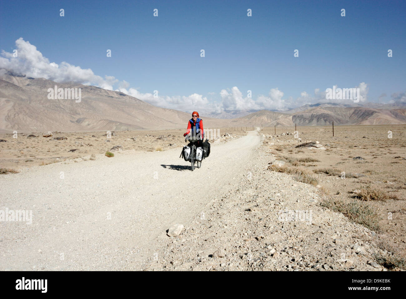 Foreign female tourist riding on a fully loaded touring bicycle on the ...