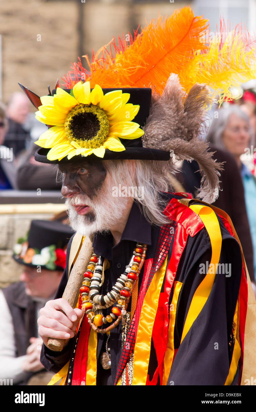 male Morris dancer with black face and yellow sunflower at Skipton ...