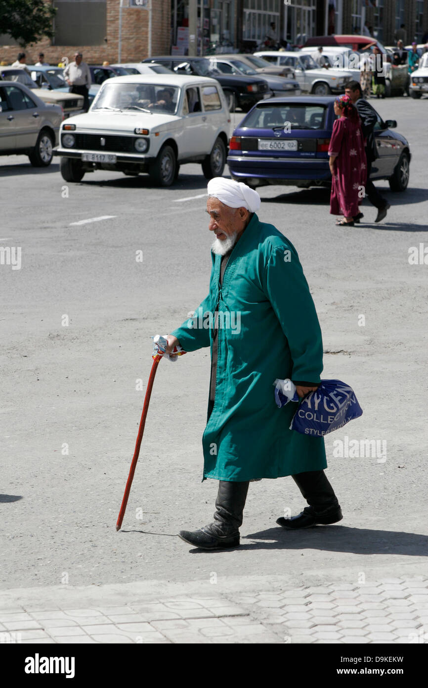 Traditionally dressed old Tajik man walking on the street of Dushanbe ...