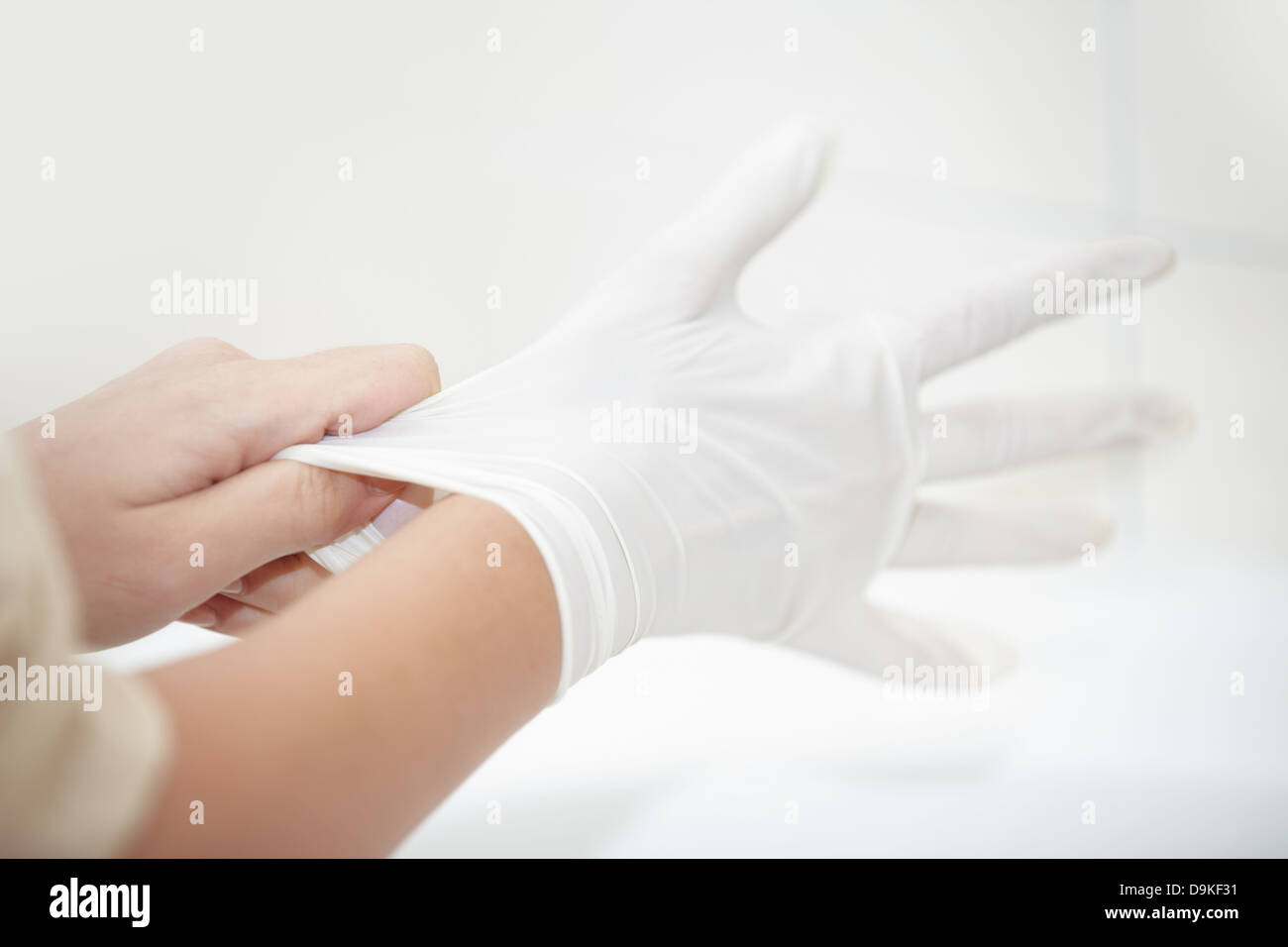 Hands of human taking on rubber gloves Stock Photo - Alamy