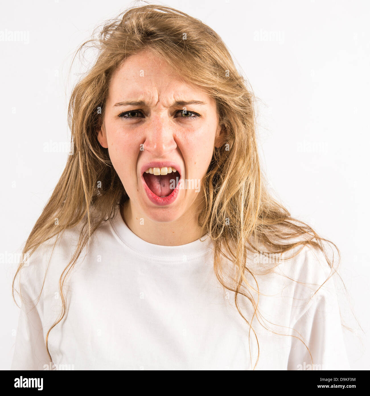 An angry furious shouting yelling young woman with long blonde hair ...