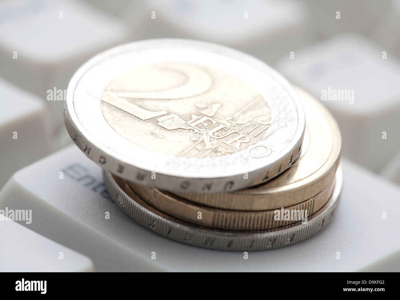 Euro coins over computer keyboard Stock Photo - Alamy