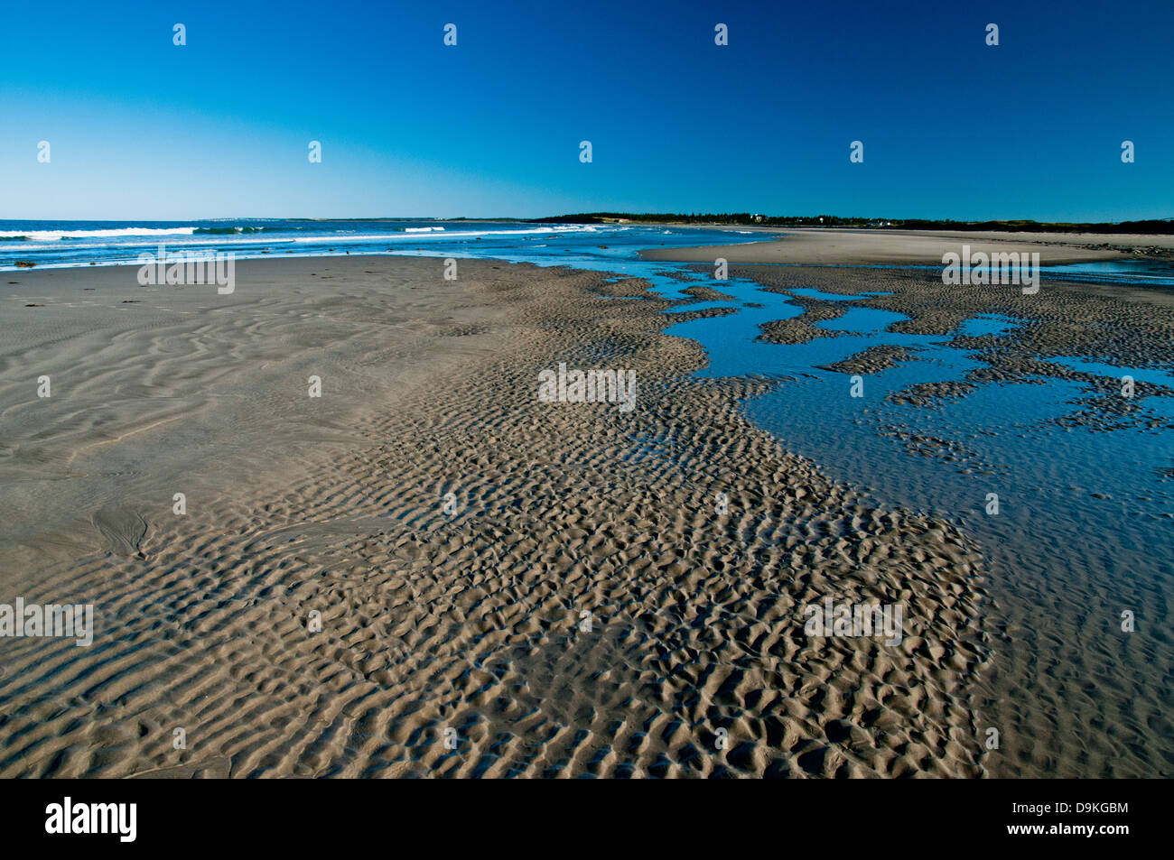Coastal beach with tide going out ,leaving behind intricate patterns in ...