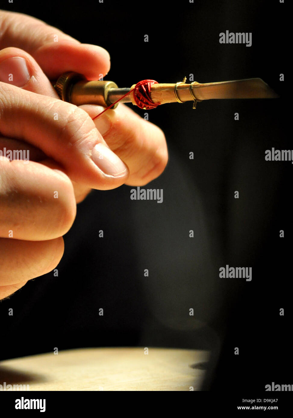 Binding the bassoon reed with red cotton thread after drying on the ...