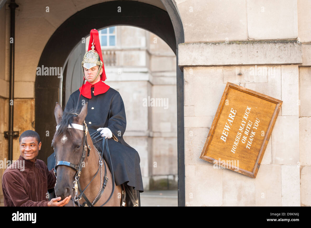 A guard on horse back at Buckingham Palace with wonky sign Stock Photo ...