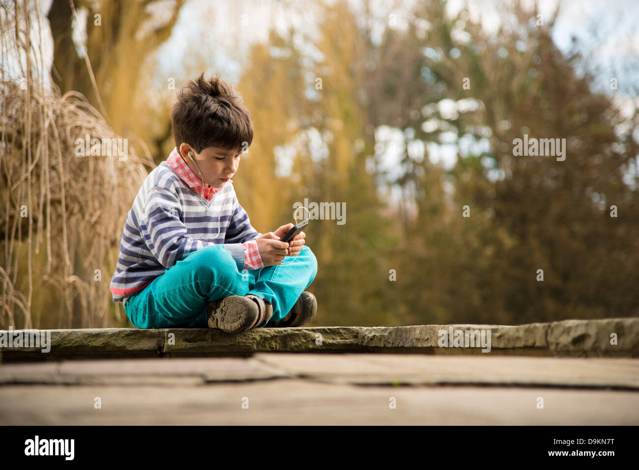 Boy playing on smartphone in playground Stock Photo - Alamy