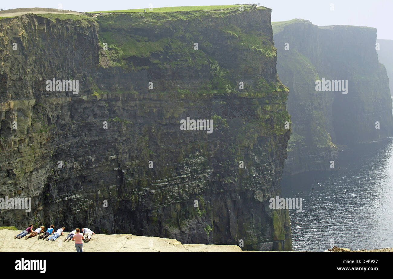 Onlookers peer over the edge of the Cliffs of Moher,Ireland Stock Photo ...