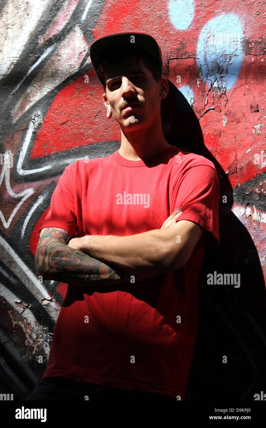 A young Rapper leaning against a wall Stock Photo - Alamy