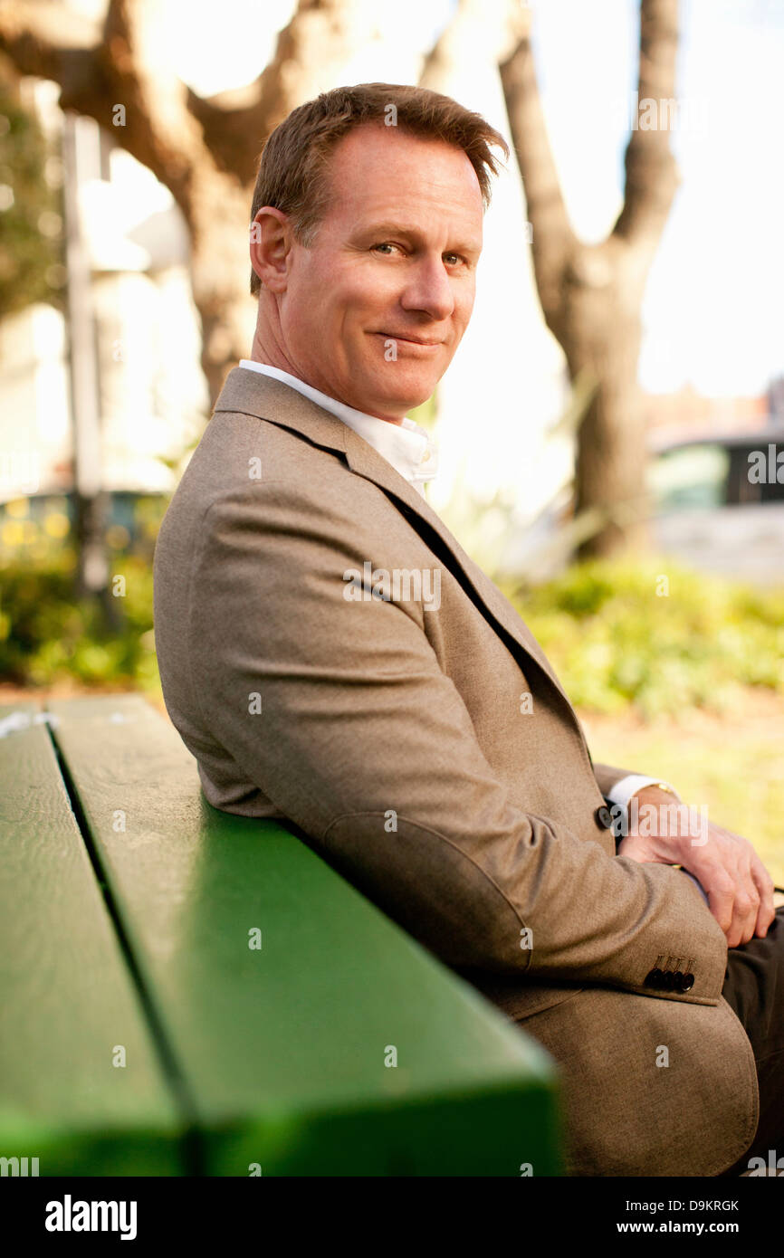 Man sitting on park bench Stock Photo - Alamy